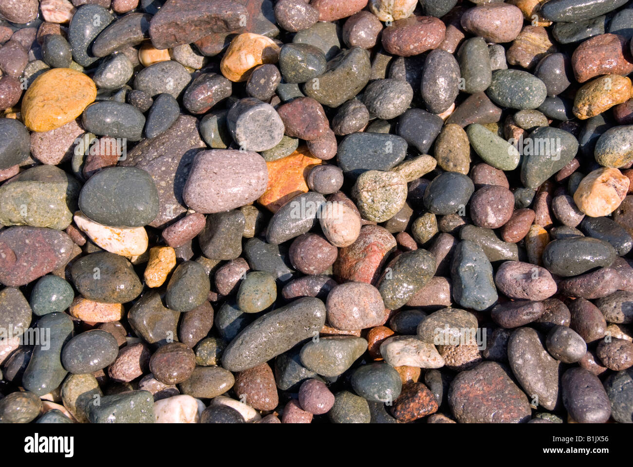 Colored stones along a shoreline in Greece Stock Photo - Alamy