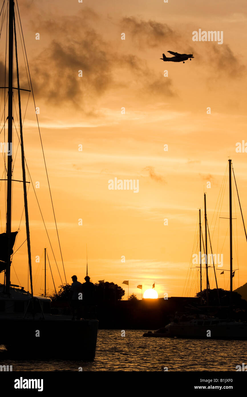 sailing yacht at anchor at sunset in the tropics with overflying ...