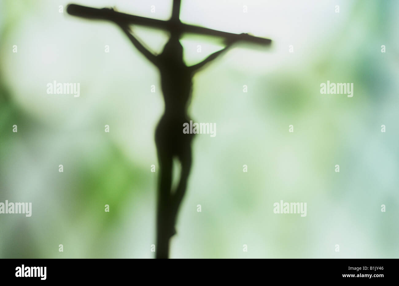 Impressionistic Jesus Christ hanging from crucifix silhouetted against ...
