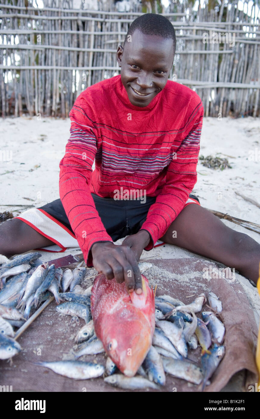 Friendly smiling fisherman in red pullover shows his freshly caught ...