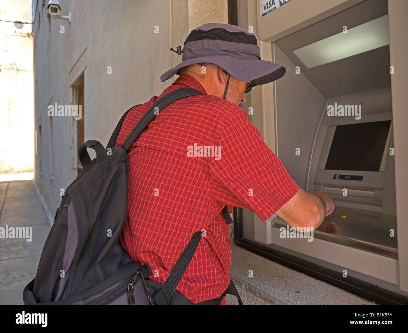 man tourist with a rucksack backpack getting money from a cash ...