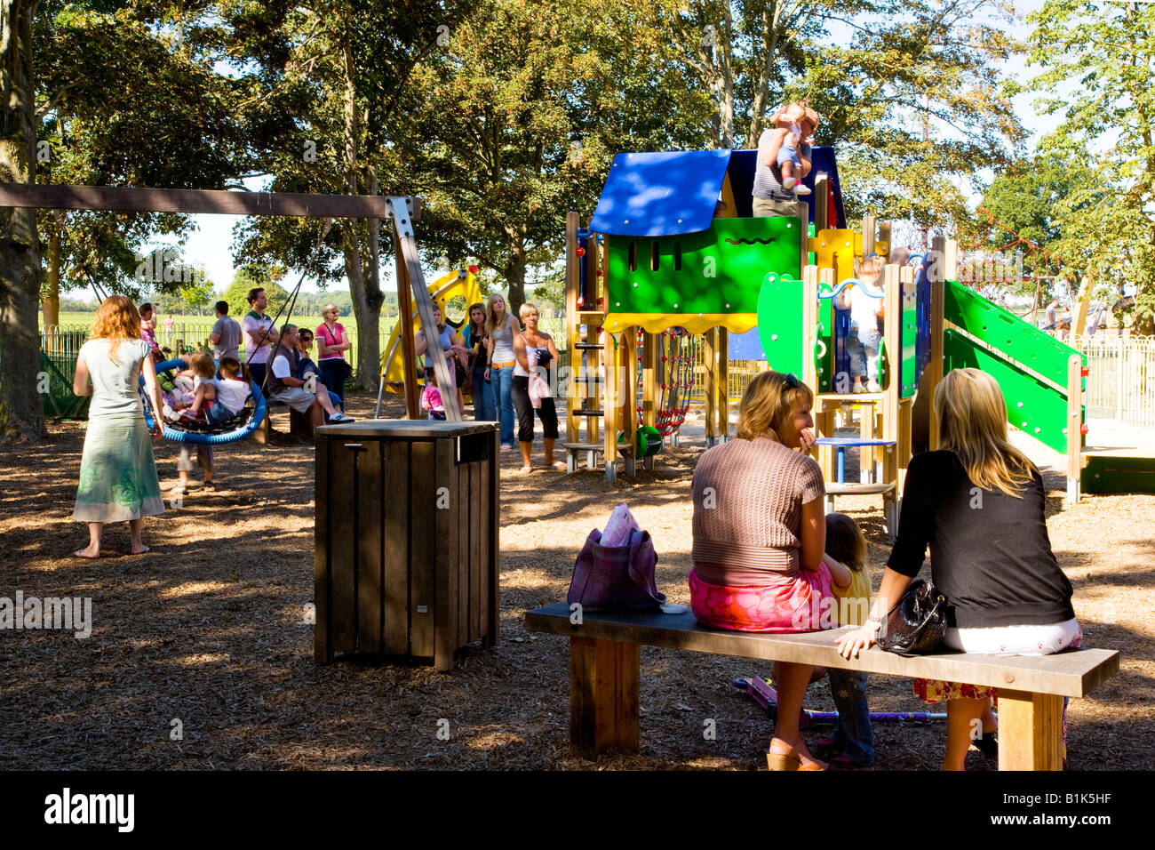 Children playing on bright modern adventure playground equipment while ...