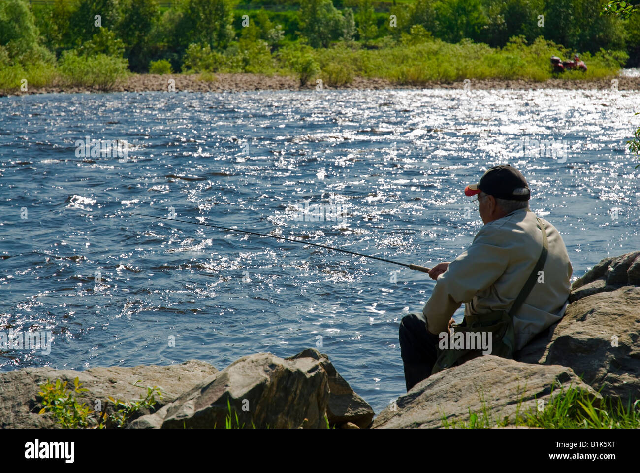An old man fishing alone on the river Stock Photo - Alamy