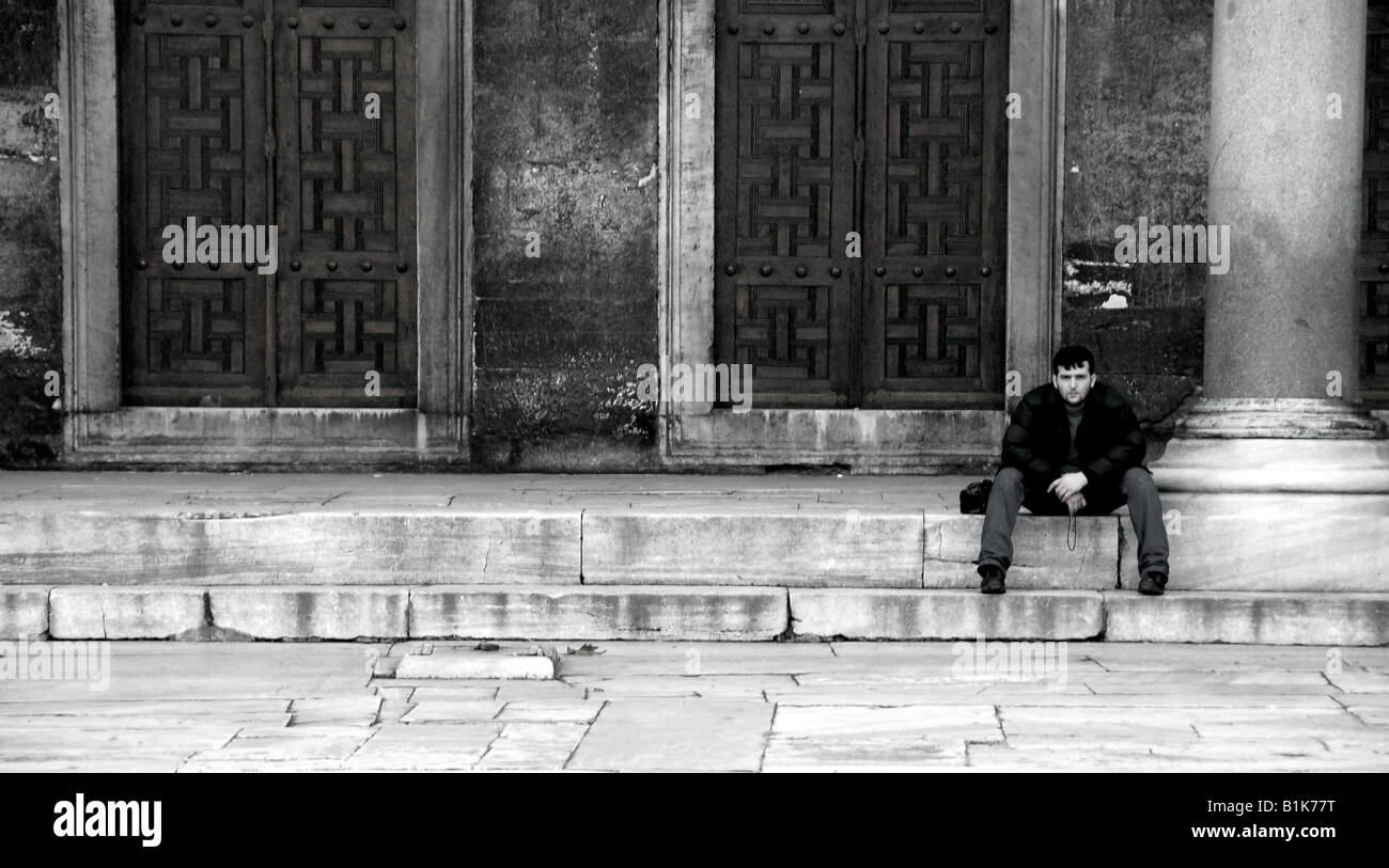 A man sits alone in the courtyard of the Blue (Sultan Ahmed) Mosque in ...