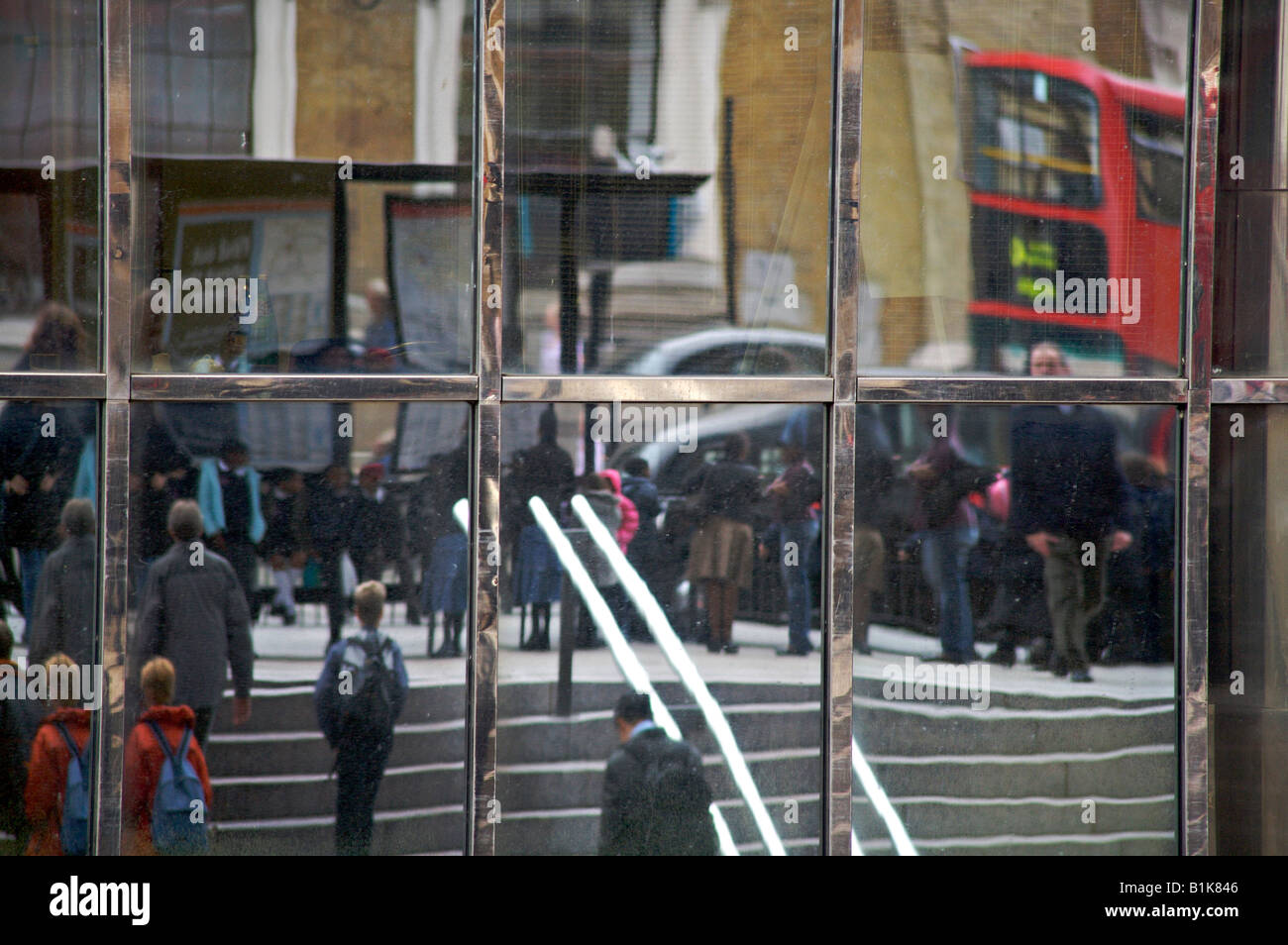Red London bus and crowd of commuters in window reflection Stock Photo ...