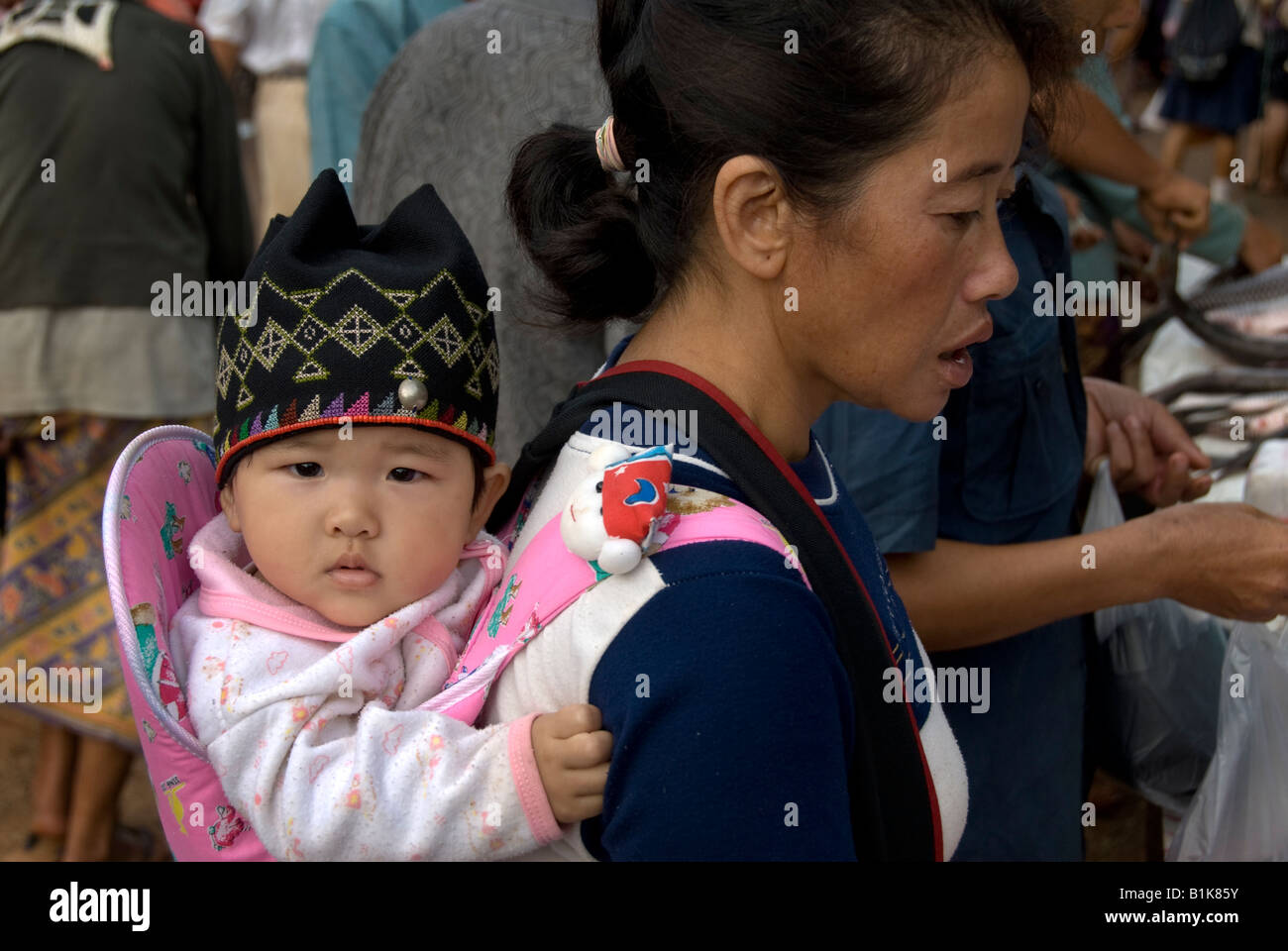 Hmong hill tribe baby strapped to it s mother s back Stock Photo - Alamy