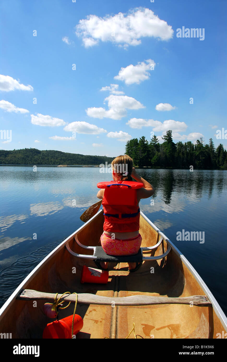 Young girl in canoe paddling on a scenic lake Stock Photo - Alamy