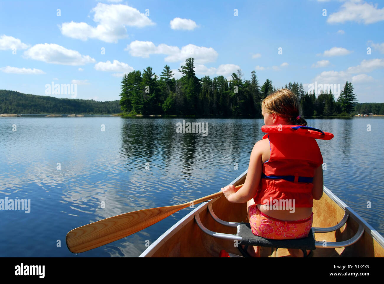 Young girl in canoe paddling on a scenic lake Stock Photo - Alamy