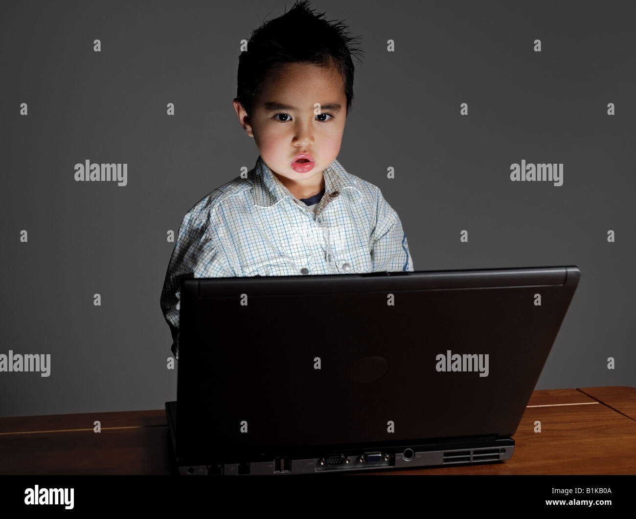 Half-asian boy using laptop Stock Photo - Alamy