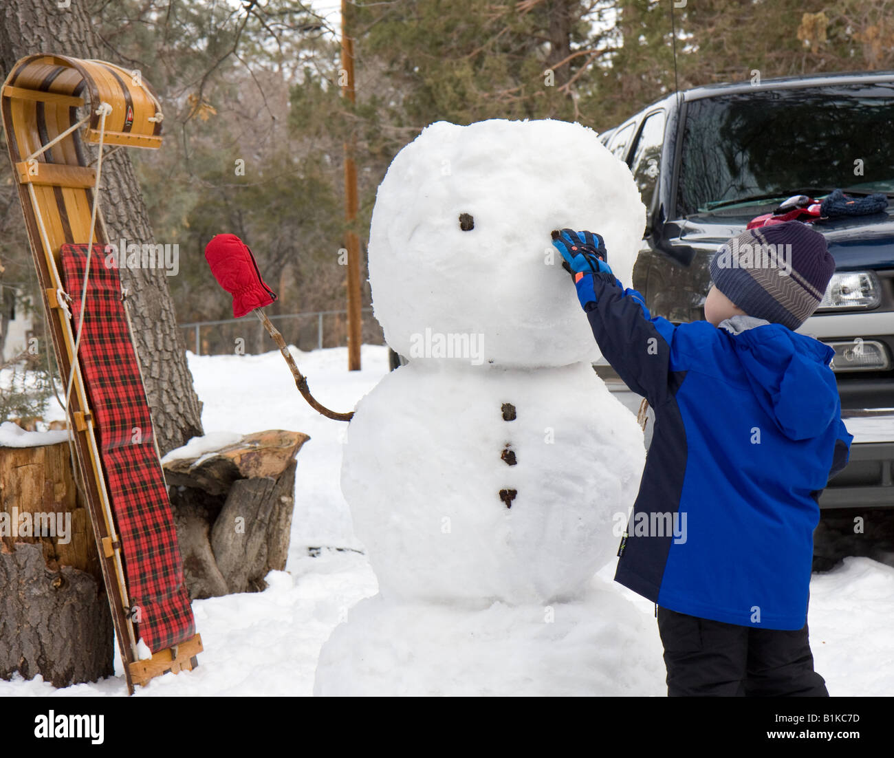 Child building a snowman Stock Photo - Alamy