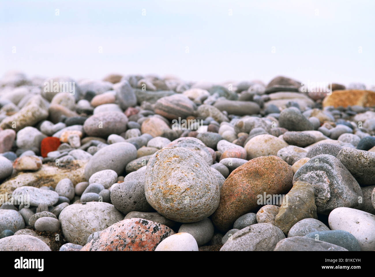 Background of colorful beach pebbles of different shapes and water ...