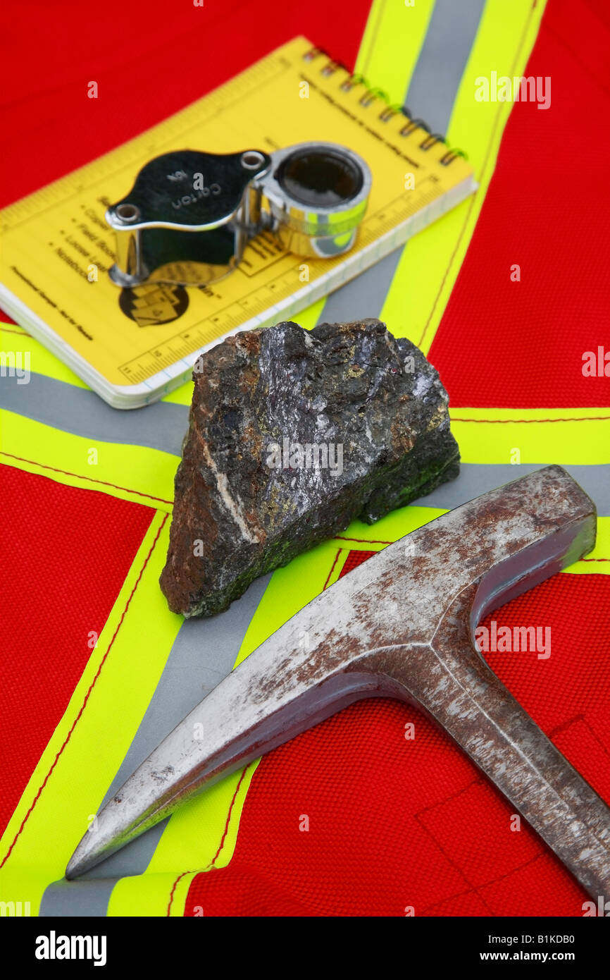 Mining concept of ore sample, geologists rock hammer, magnifier and ...