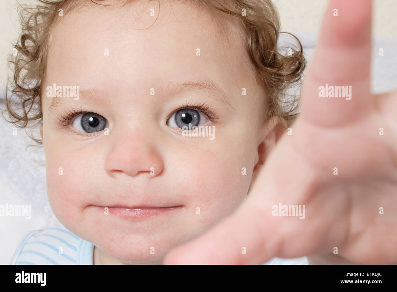 portrait cheeky little baby reaching hand out to grab Stock Photo - Alamy