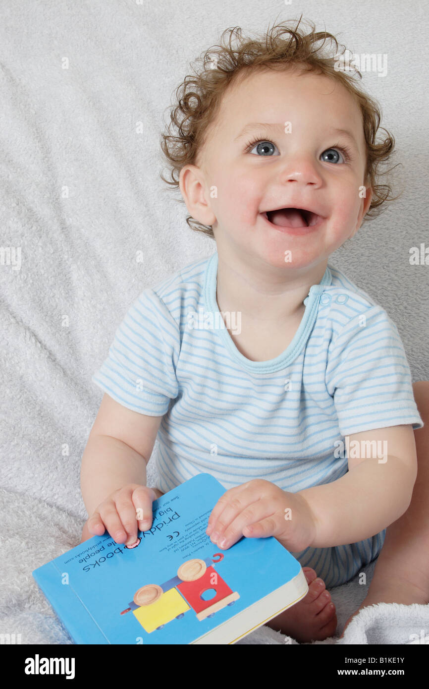happy little baby holding picture book Stock Photo - Alamy