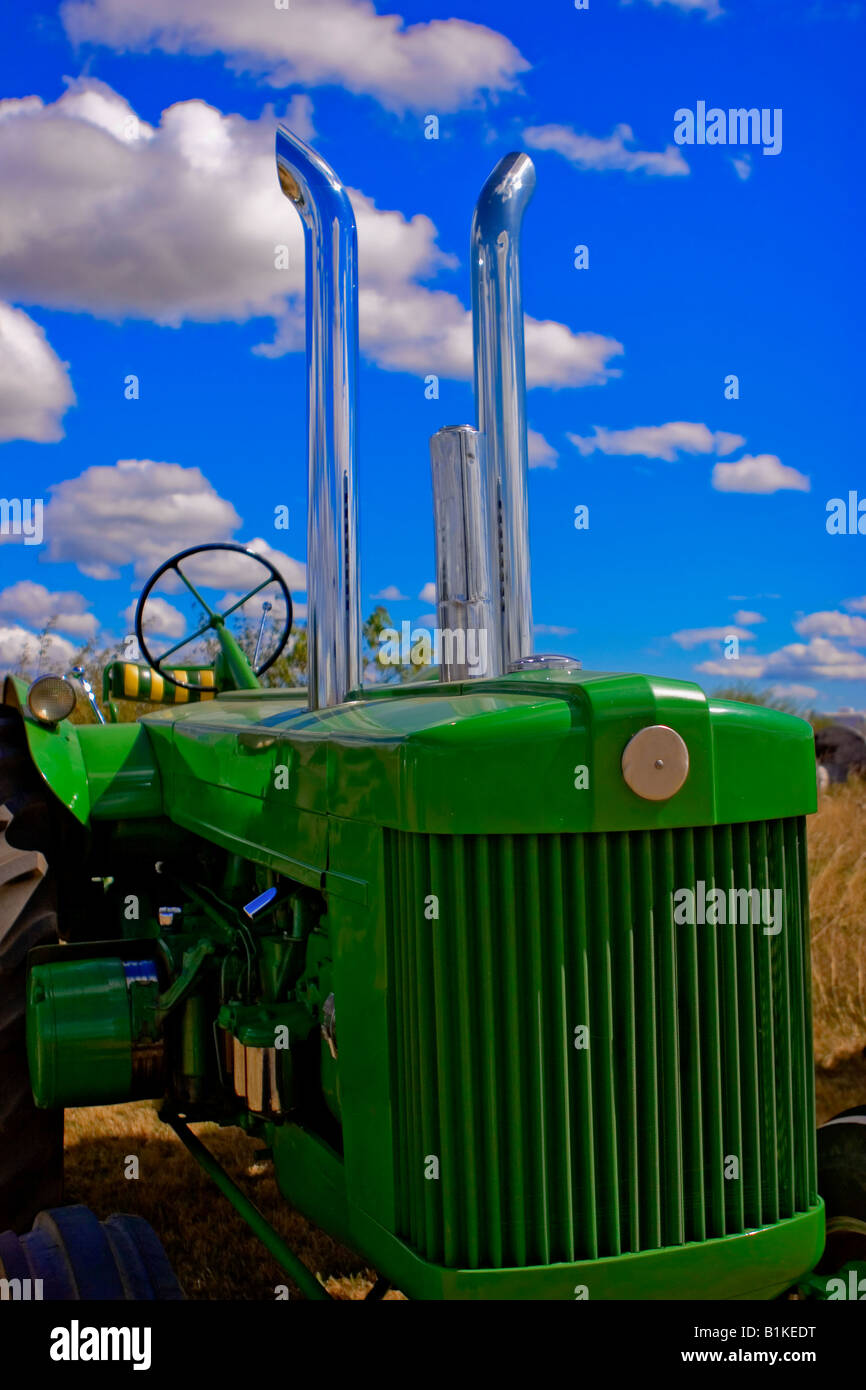 The front end of a restored antique tractor with dual chrome exhaust ...