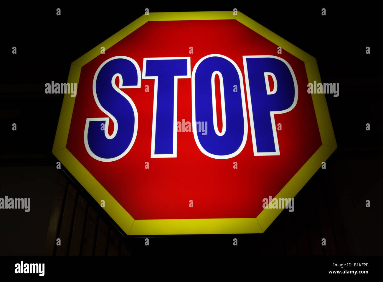 RED YELLOW AND BLUE ILLUMINATED STOP SIGN BLACK BACKGROUND HORIZONTAL ...
