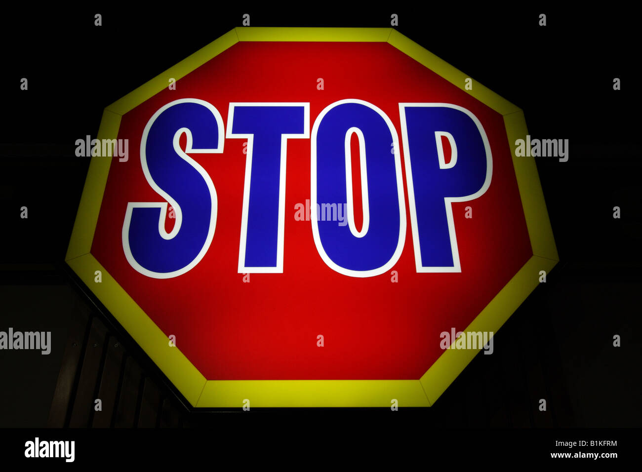 RED YELLOW AND BLUE ILLUMINATED STOP SIGN BLACK BACKGROUND HORIZONTAL ...