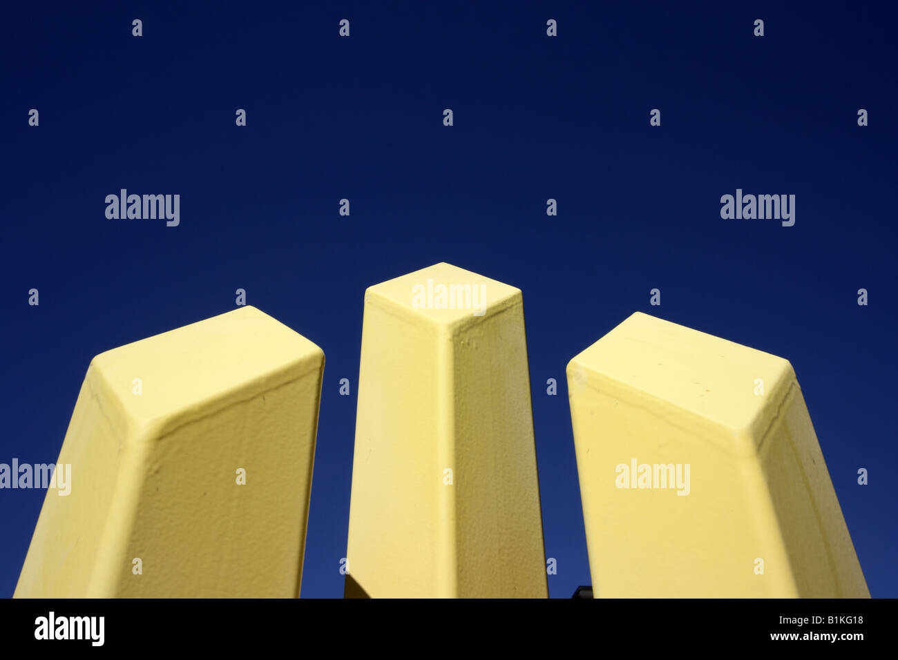 THREE YELLOW POLE TOPS AGAINST VIBRANT BLUE SKY HORIZONTAL BDB11117 ...