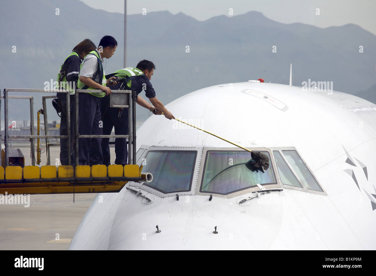 Men cleaning windscreen of a plane, Hong Kong, China Stock Photo - Alamy