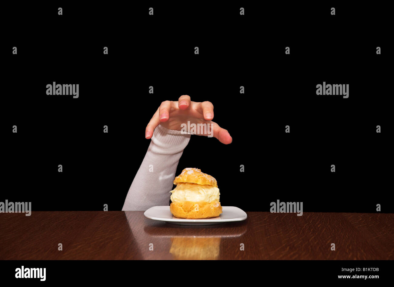 Womans hand reaching for a cake on table Stock Photo - Alamy