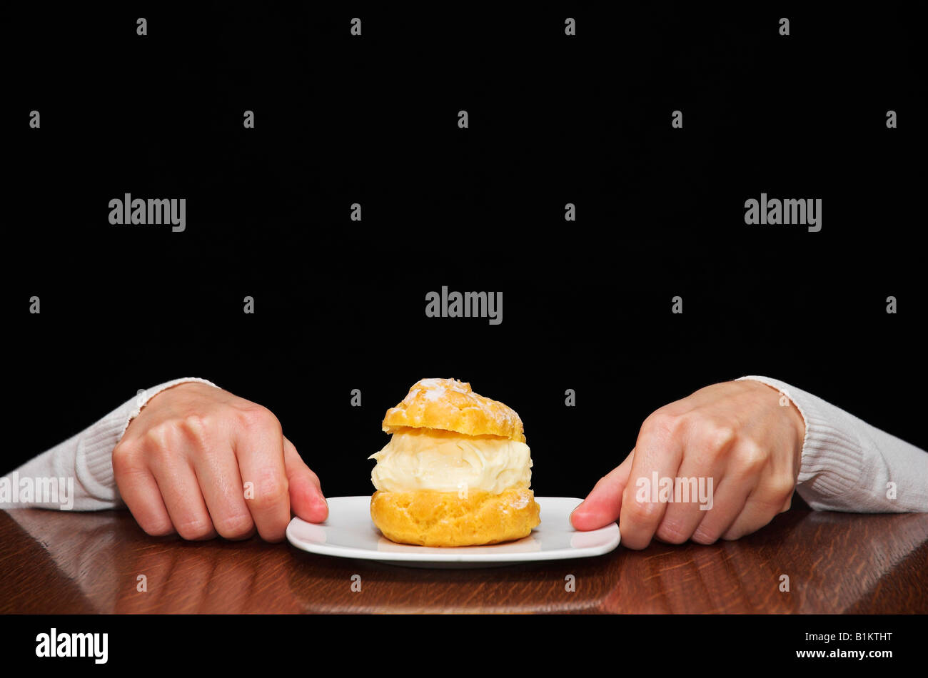 Womans hands reaching for a cake on table Stock Photo - Alamy