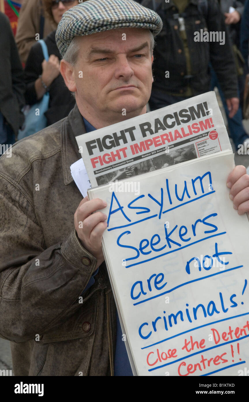 Man in cloth cap with poster 'Asylum seekers are not criminals' in LMHR ...