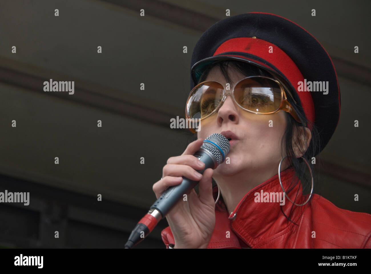 Singer in red leather jacket and peaked cap with red band at start of ...