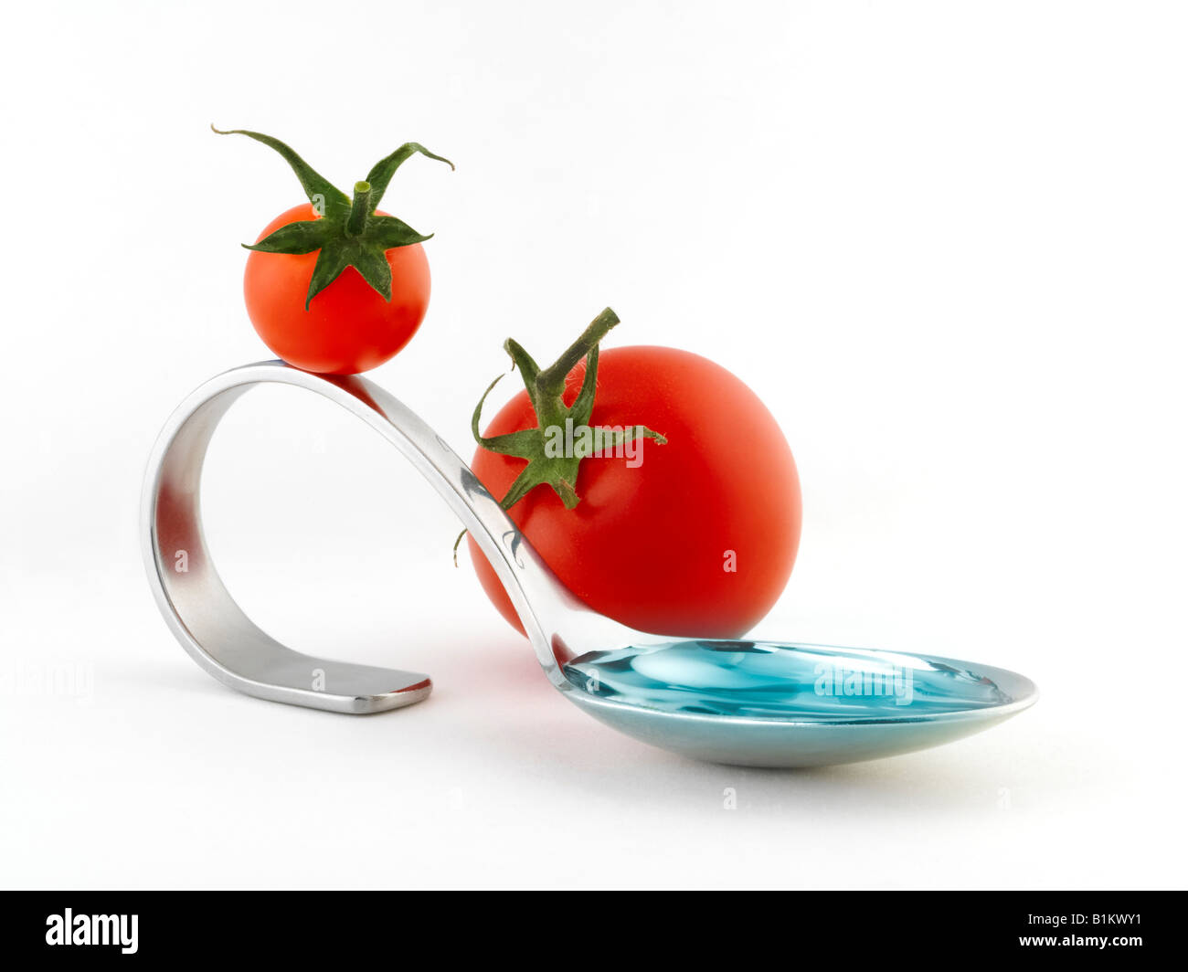 red tomatoes and spoon, isolated on white background Stock Photo - Alamy