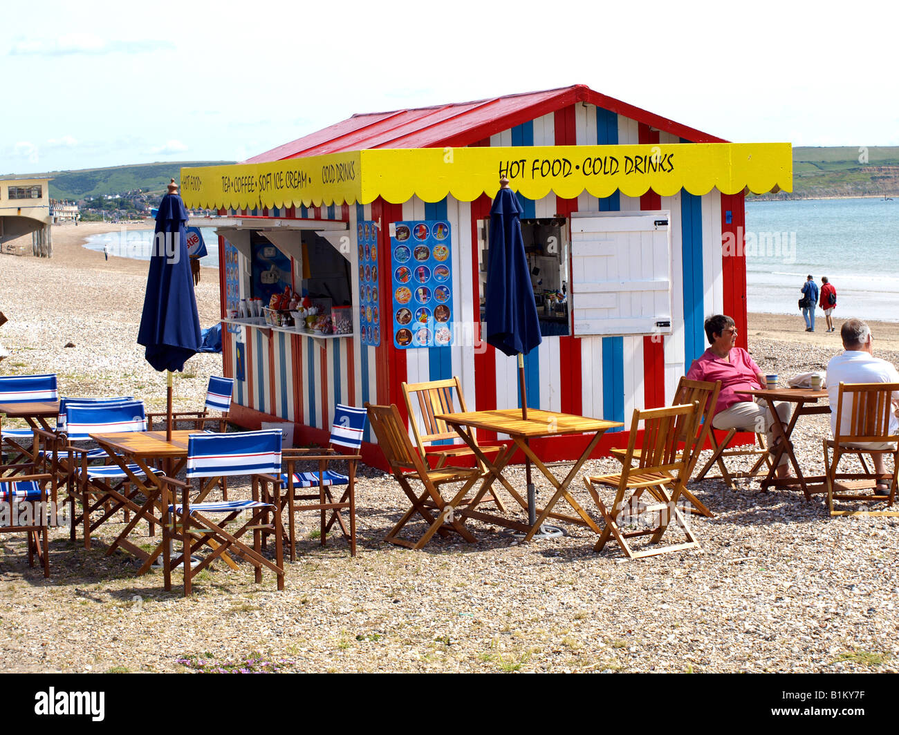 A colourful beach cafe with tables and chairs on the beach at weymouth ...