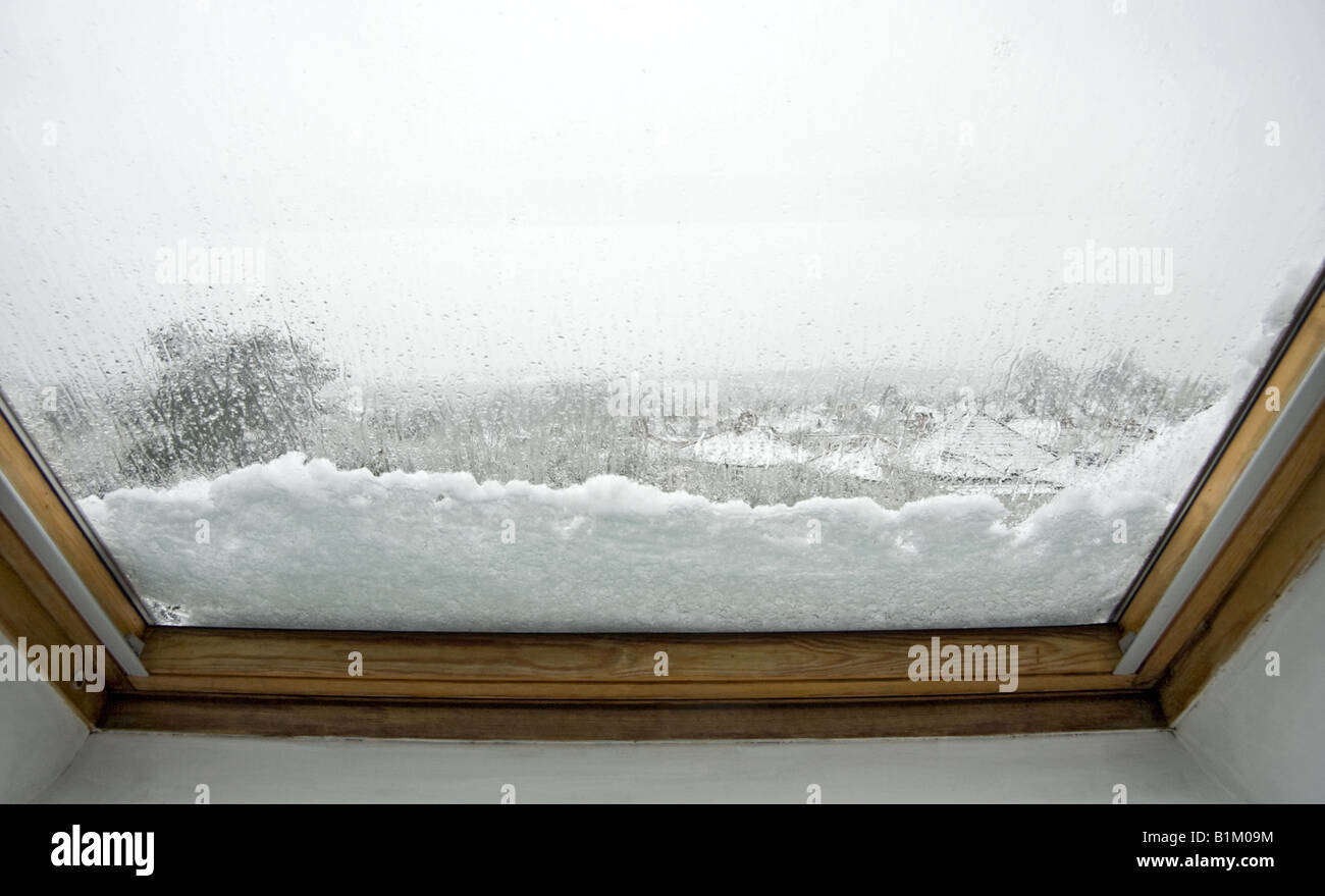Snow lying on a window looking out over a London suburb Stock Photo - Alamy