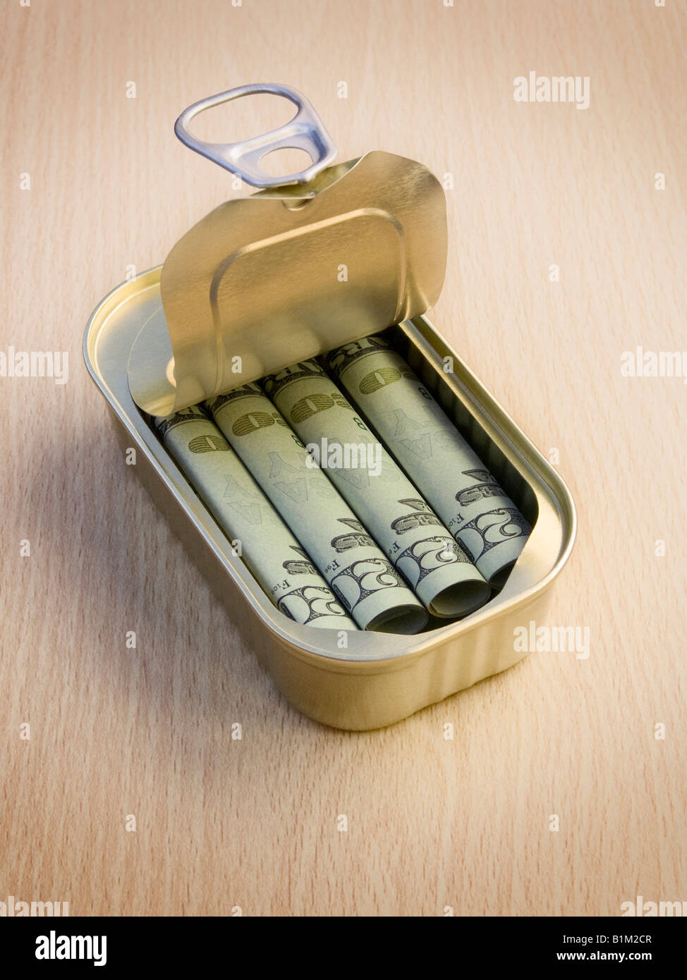 Ring Pull Tin containing rolled 20 Dollar notes on wooden surface ...