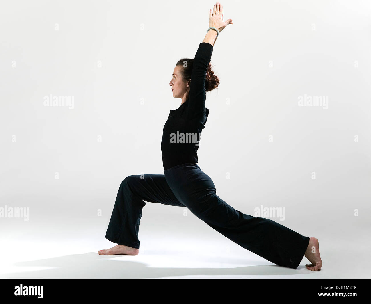 profile view of woman practicing the warrior pose Stock Photo - Alamy