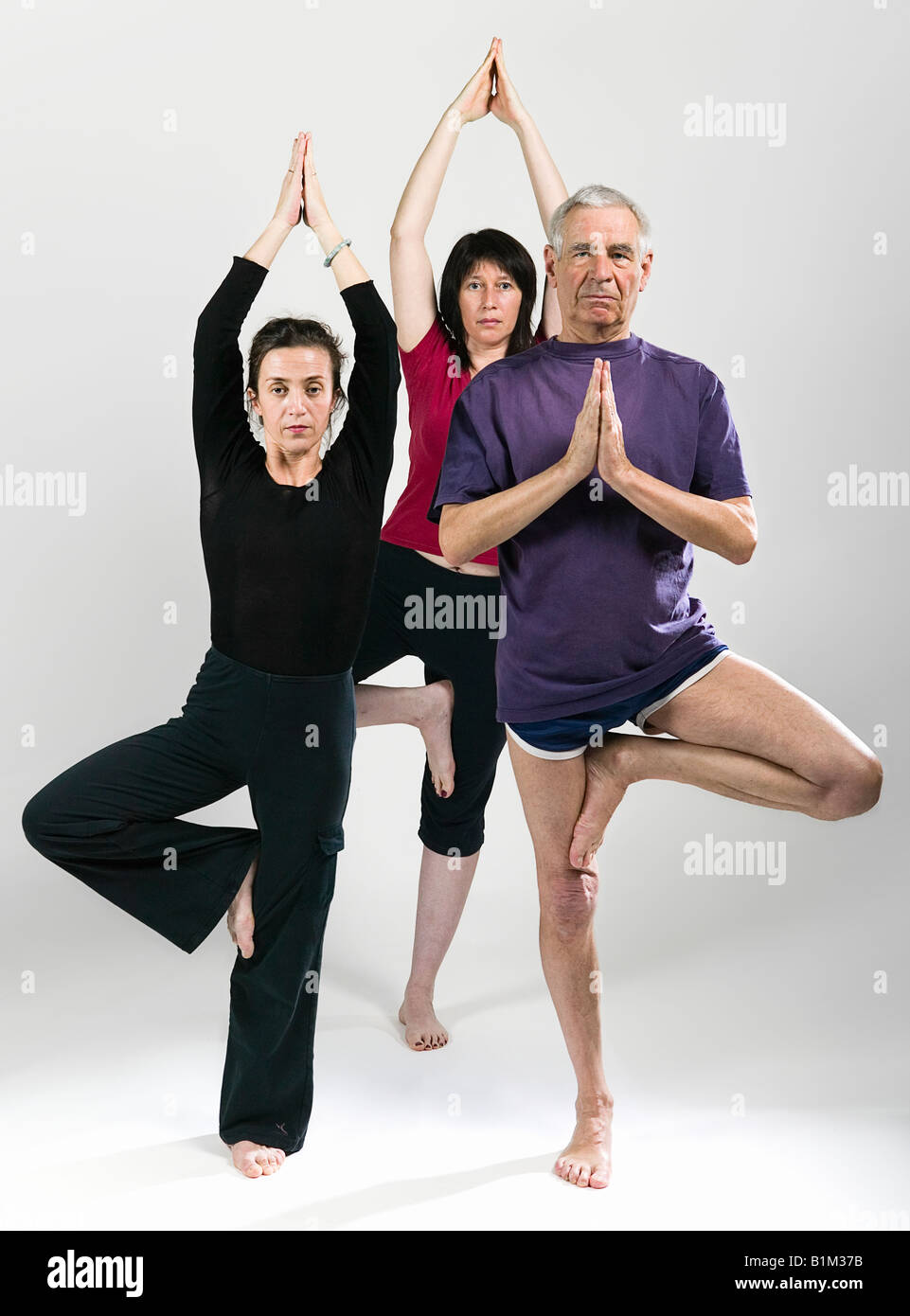 frontal view of three people in the tree pose Stock Photo - Alamy