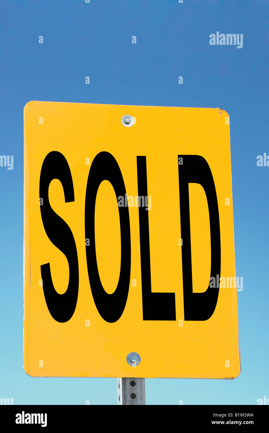 Sign SOLD on a yellow road sign and blue sky Stock Photo - Alamy