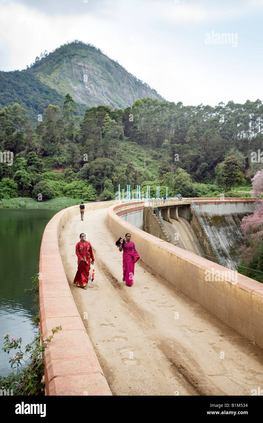 Two Indian women walk over Kundala Dam constructed across Kuravan and ...
