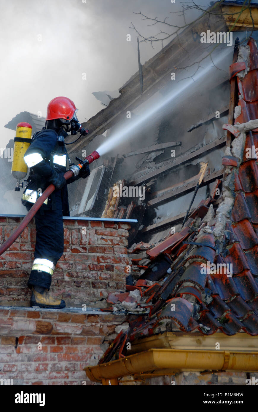 Firemen on a roof Stock Photo - Alamy