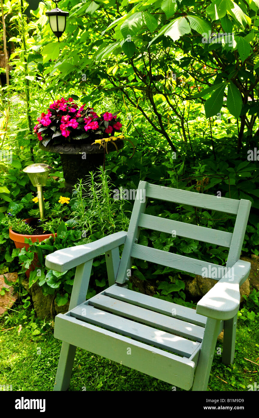 Wooden chair in a secluded corner of lush green garden Stock Photo - Alamy