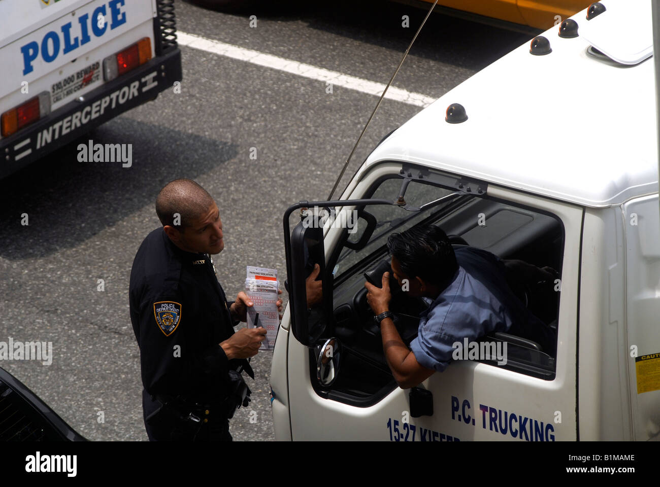 An NYPD office issues a ticket to the truck driver on Ninth Avenue in ...