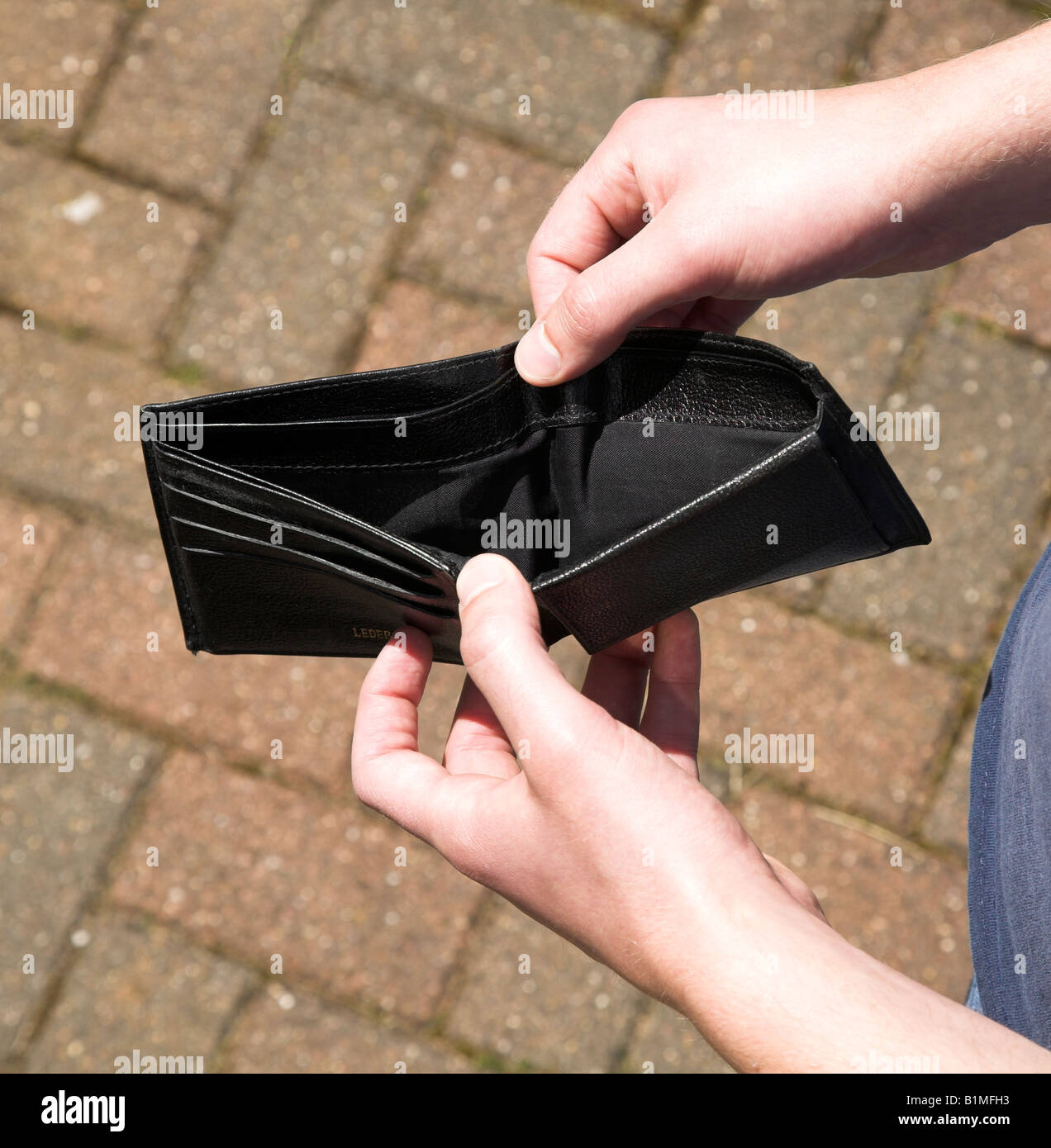 Youth holding an empty wallet Stock Photo - Alamy