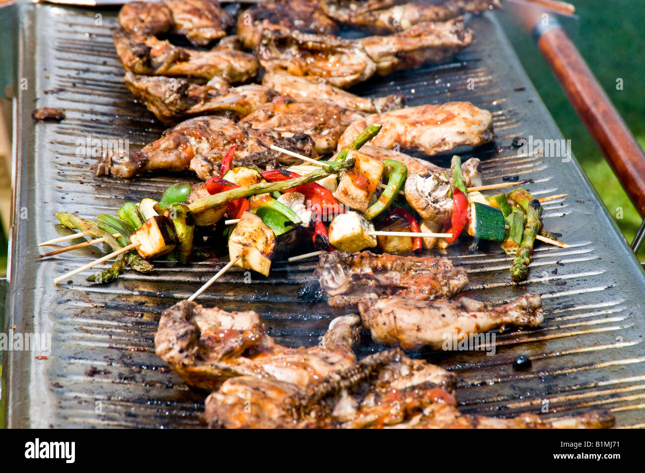 Chicken and vegetables cooking on a large open air barbeque Caribbean ...