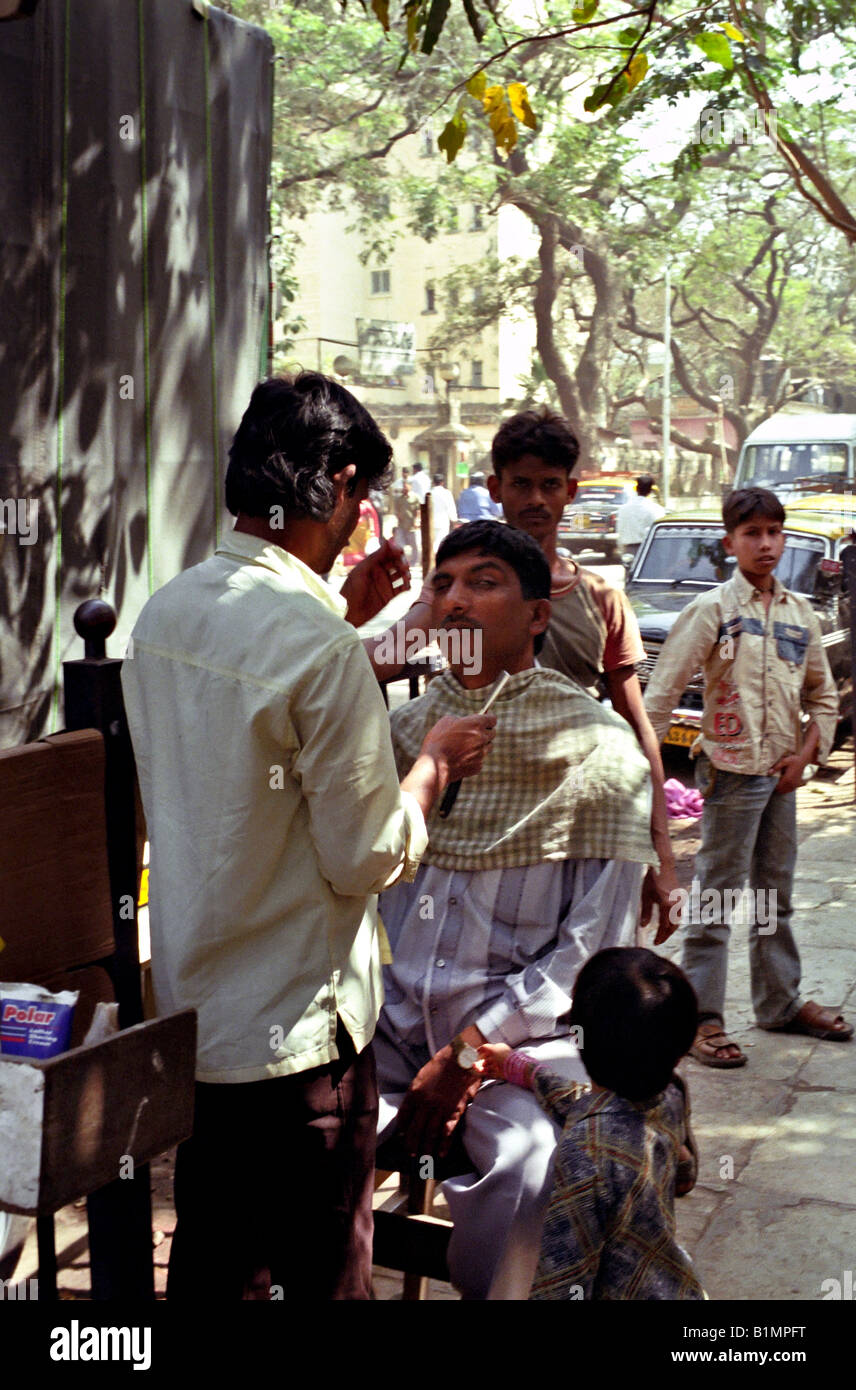 INDIA MUMBAI MAHARASHTRA Portable barber shop under a tree with the ...