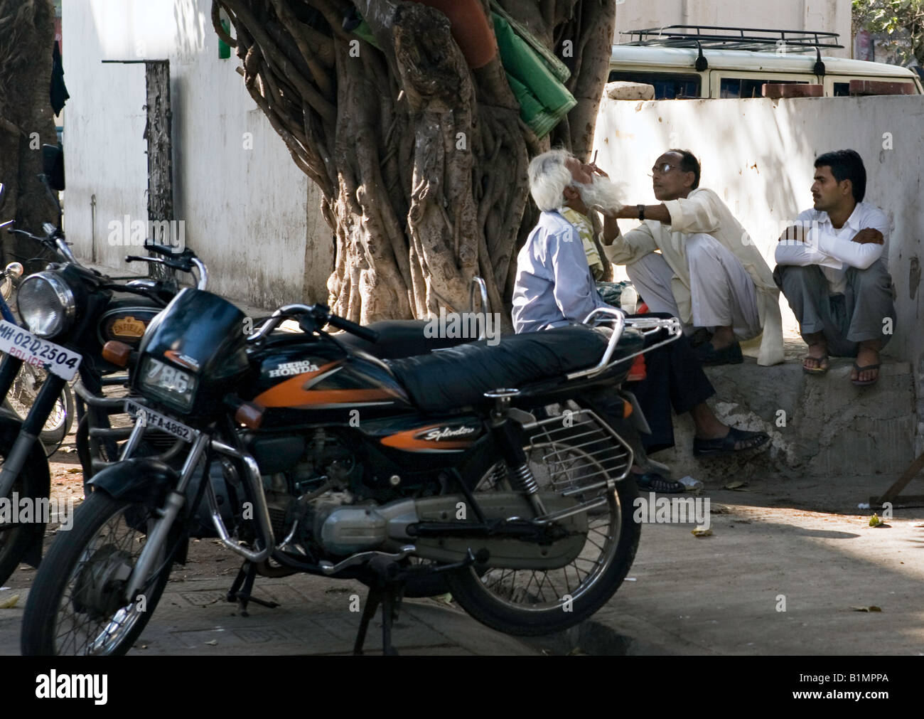 INDIA MUMBAI MAHARASHTRA Portable barber shop under a tree with the ...