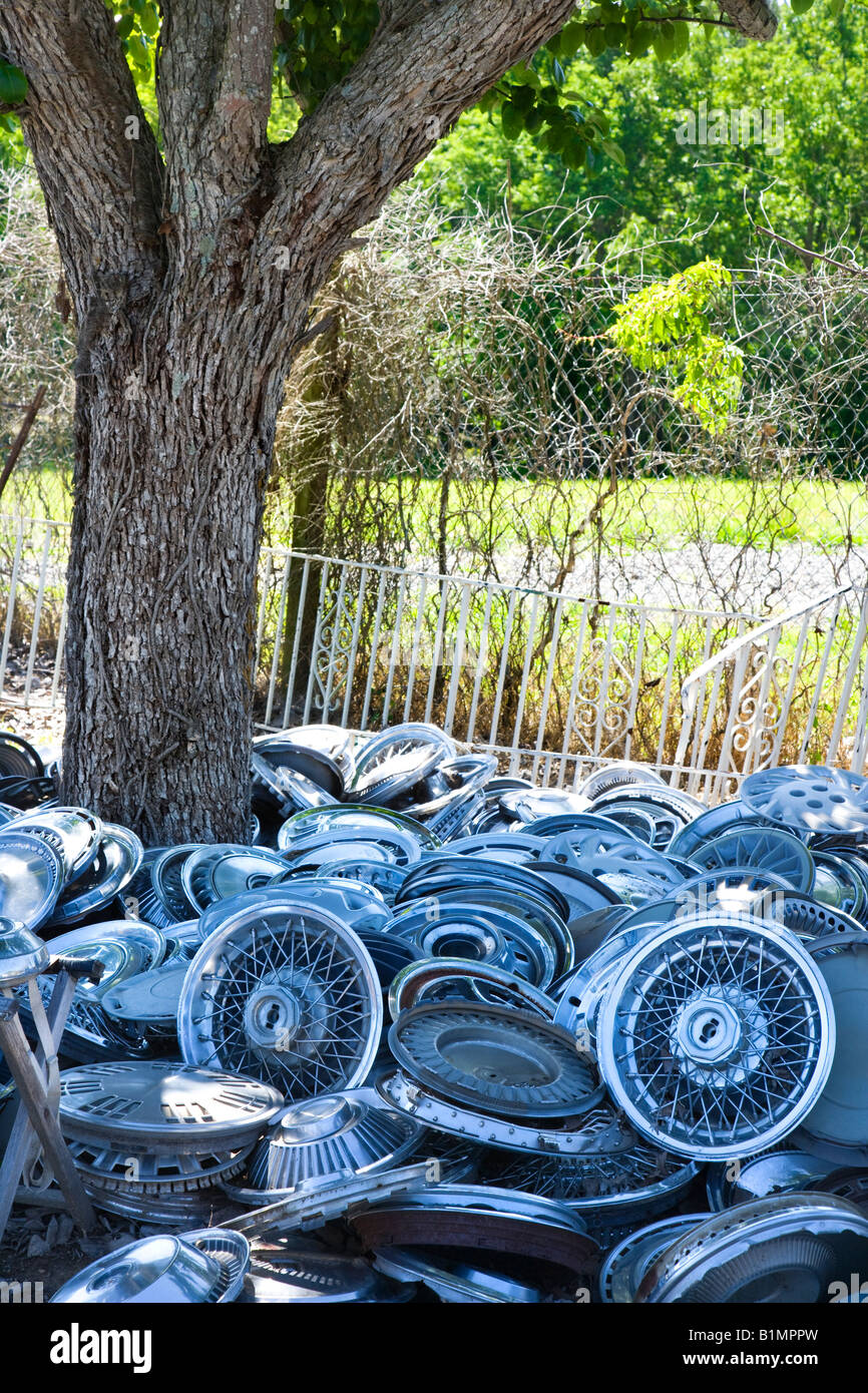 Pile of old hubcaps on the ground next to tree Stock Photo - Alamy