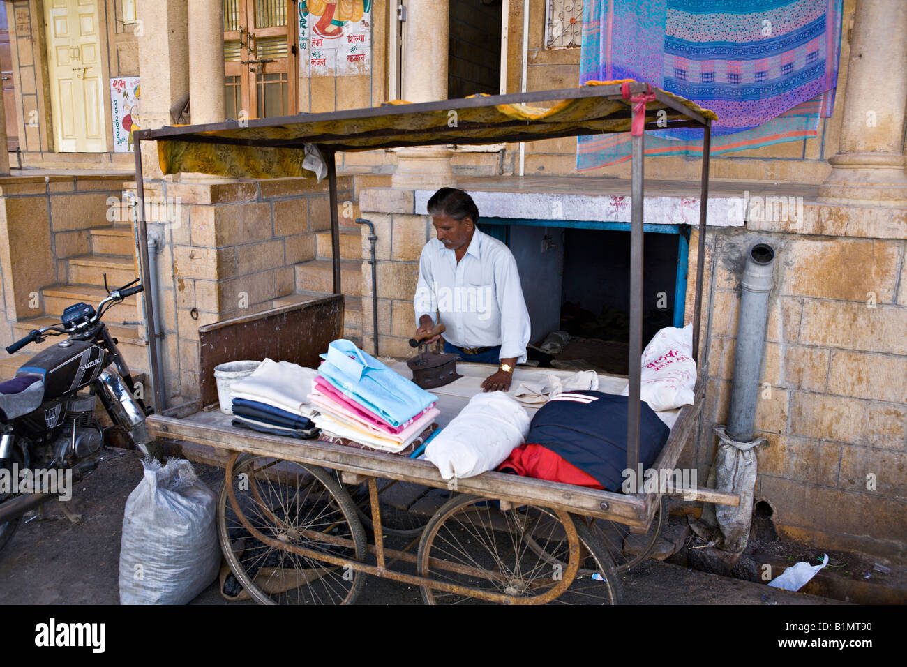 INDIA JAISALMER RAJASTHAN Indian man ironing clothes with a charcoal ...
