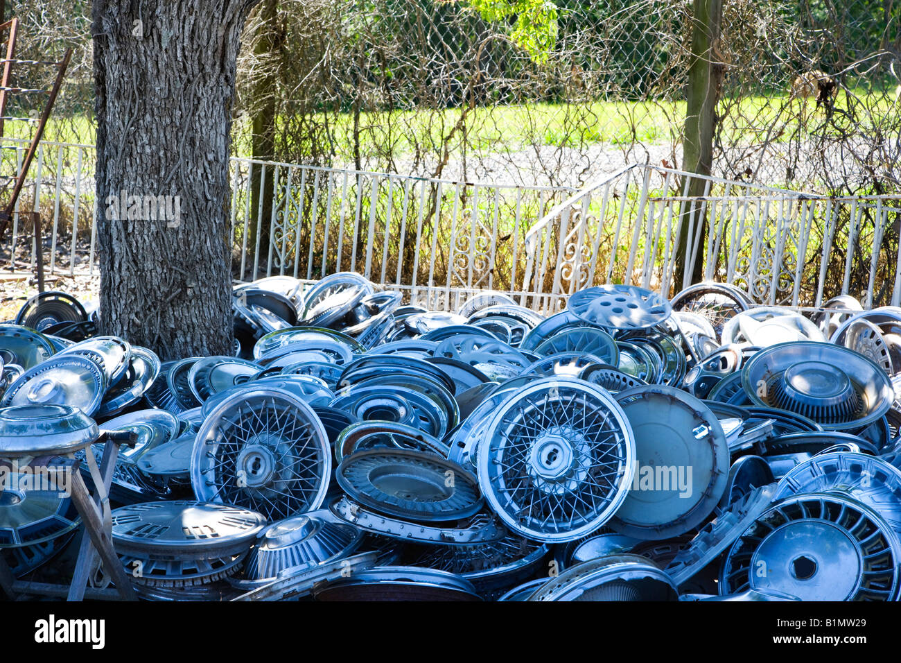 Stacks of old hubcaps on the ground next to tree Stock Photo - Alamy