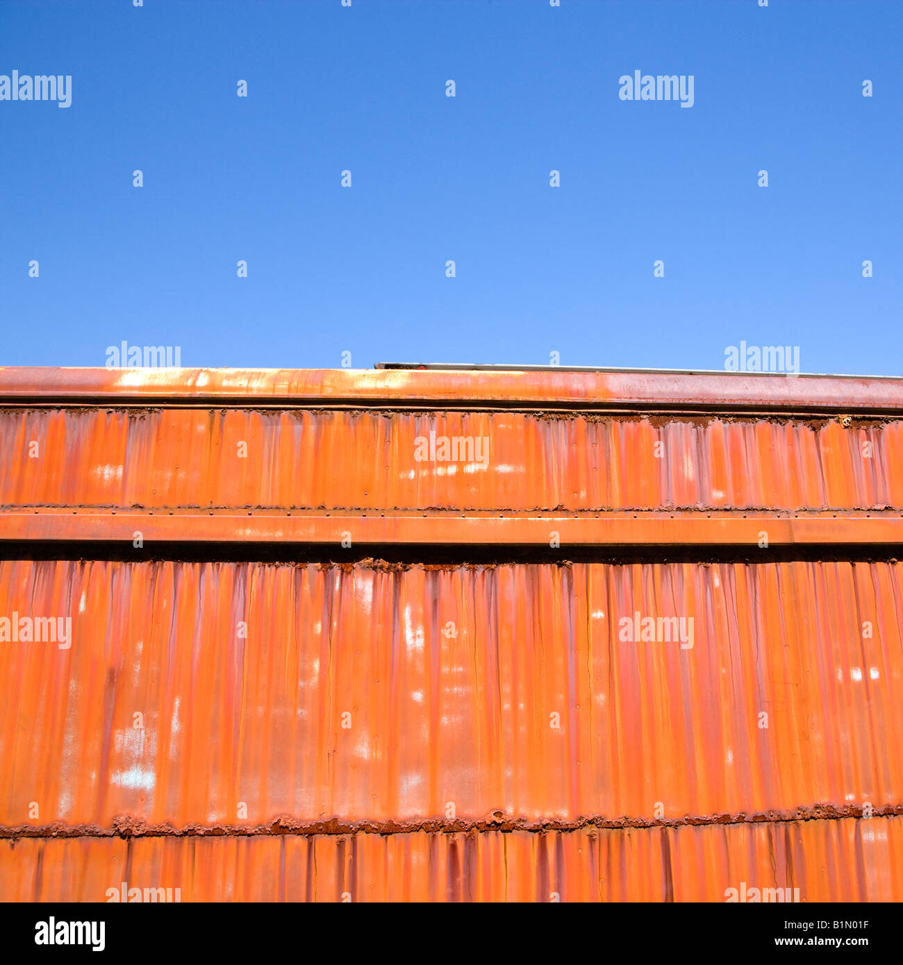 Metal orange siding and blue sky Stock Photo - Alamy