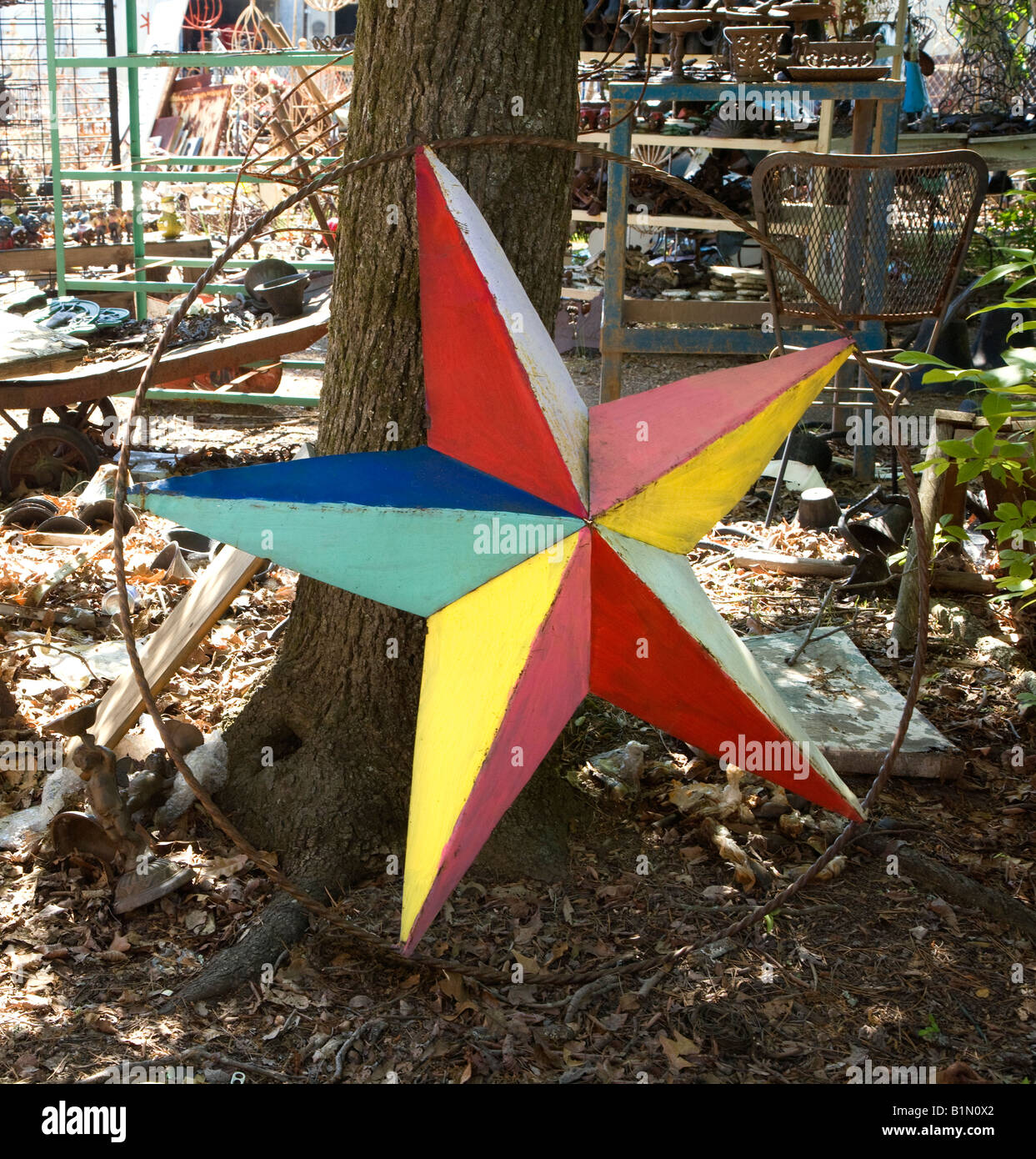 Colorful painted star made of metal leaning against tree Stock Photo ...