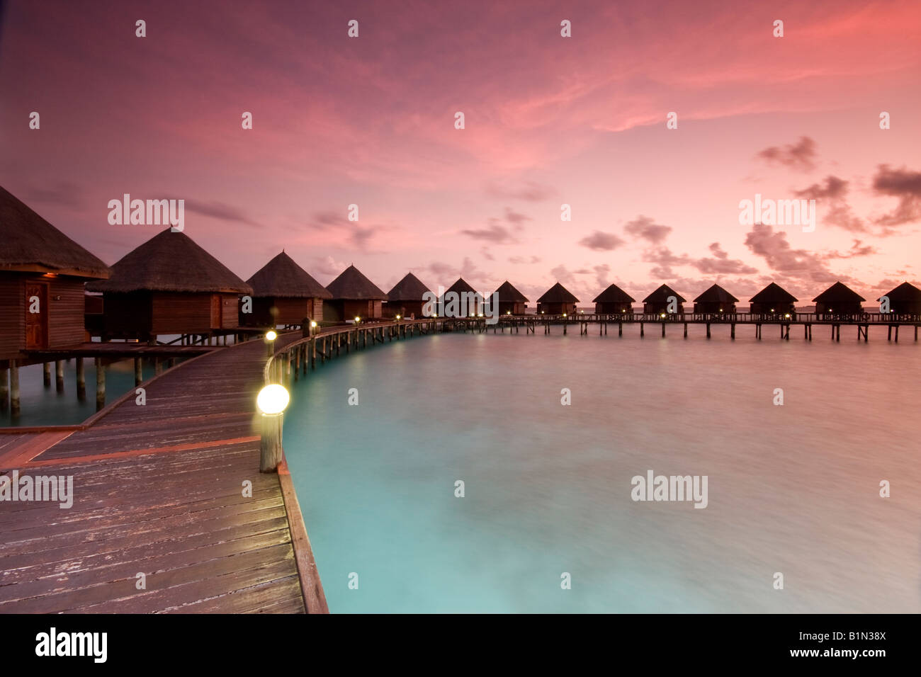 Over water hotel room on island resort at sunset Stock Photo - Alamy