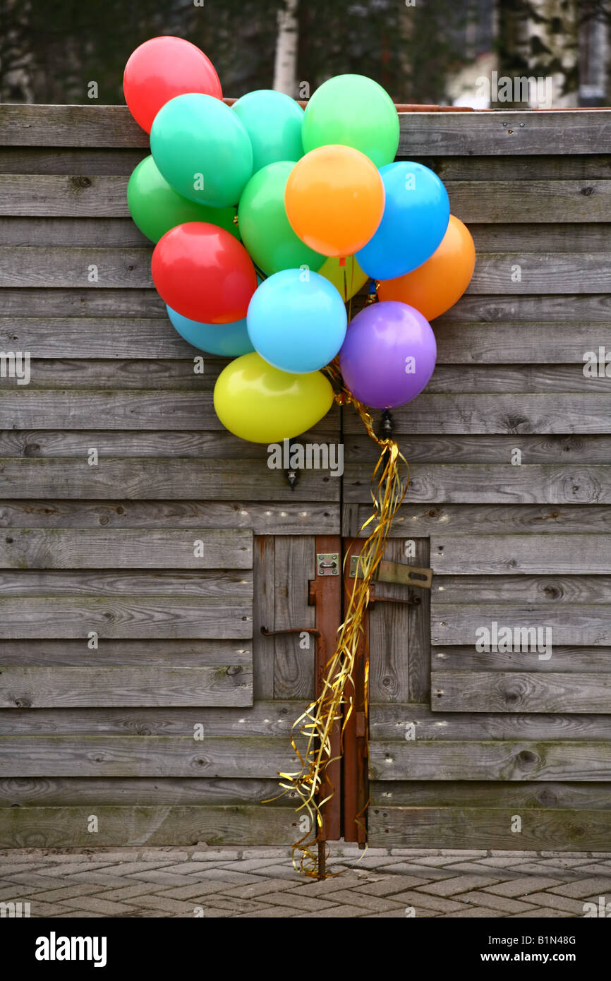 A bunch of colorful balloons attached to wooden gates Stock Photo - Alamy