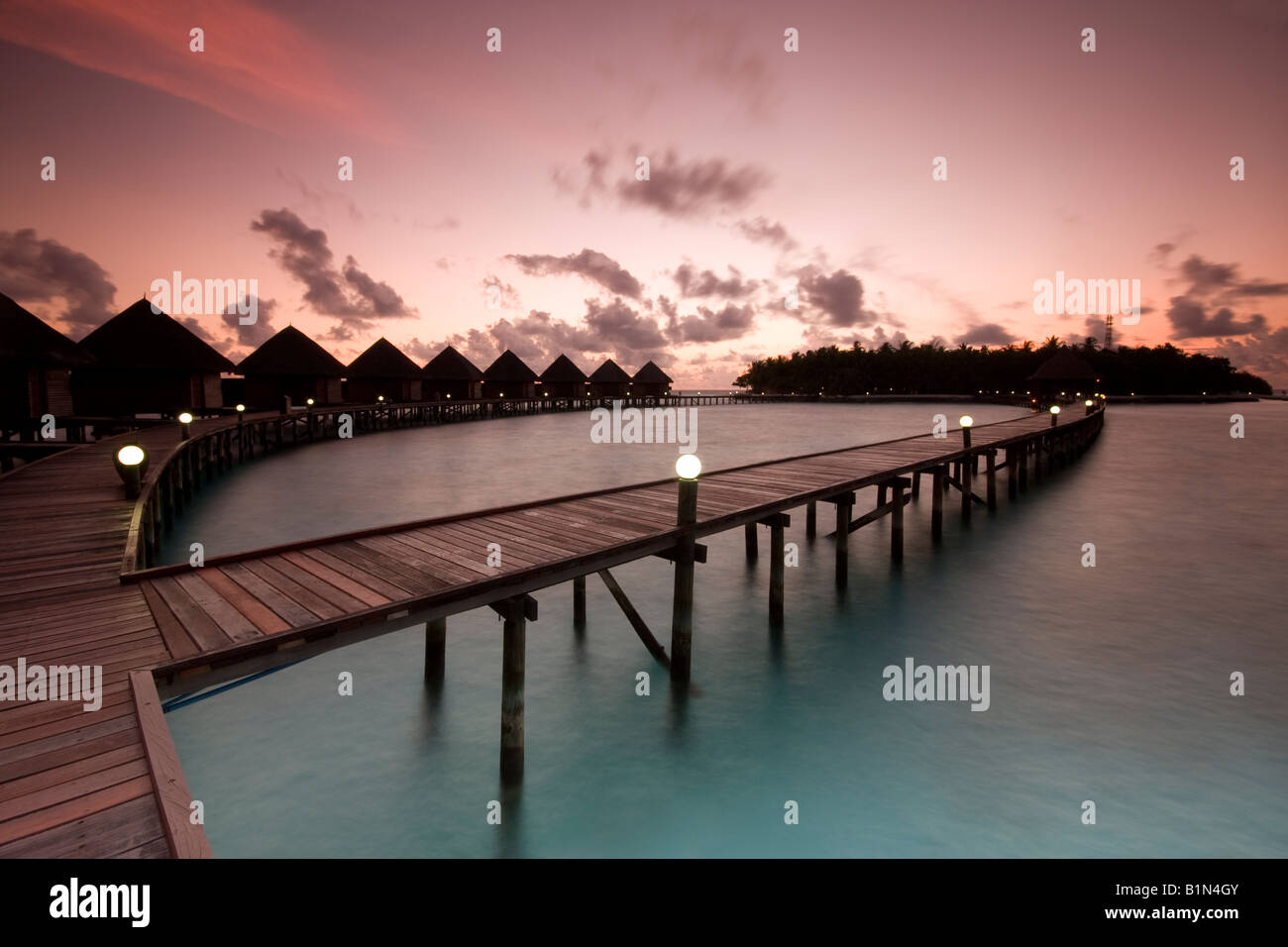 Over water Hotel Room on island resort at sunset Stock Photo - Alamy